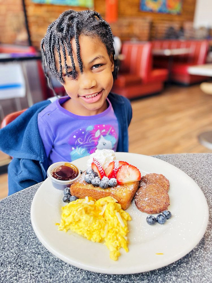 The interior shows the diner's warm atmosphere with its signature red booths and exposed brick – where breakfast dreams come true daily.