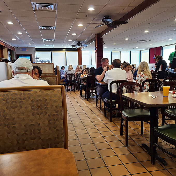 The dining room hums with the universal language of satisfied eaters. Every table tells a different story with the same happy ending.