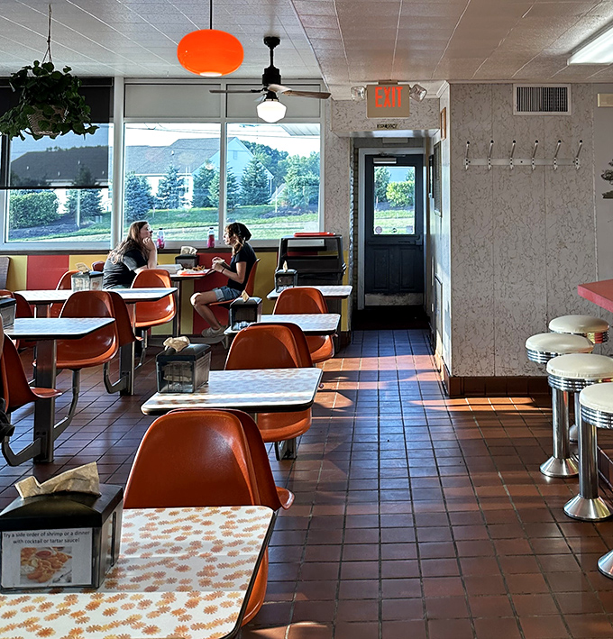 Sunlight streams through windows onto those signature orange chairs, creating the perfect stage for the main event: exceptional fried chicken.
