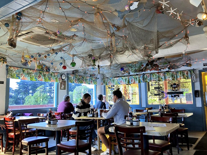 Diners gather under a canopy of fishing nets and twinkling lights, creating memories as delicious as the food.