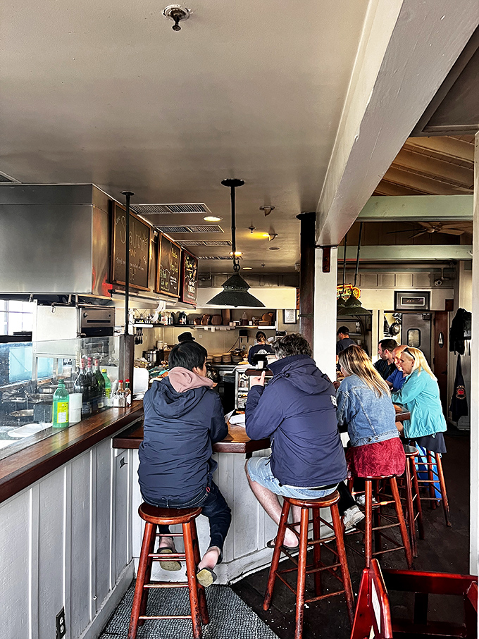 Happy diners discovering that the best seafood experiences happen in the most unpretentious, authentic waterfront settings.