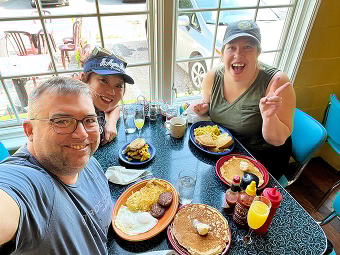 Happy diners showing off their breakfast bounty&mdash;the universal language of "you've got to try this" captured in one perfect moment.
