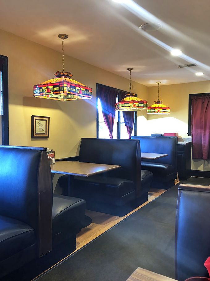 Those stained-glass pendant lights hanging over cozy booths create the perfect atmosphere for important food decisions.