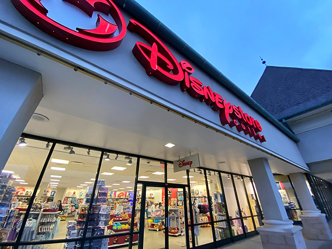 The Disney Store's glowing sign is retail pixie dust, transforming rational adults into kids who suddenly "need" that Stitch plushie.