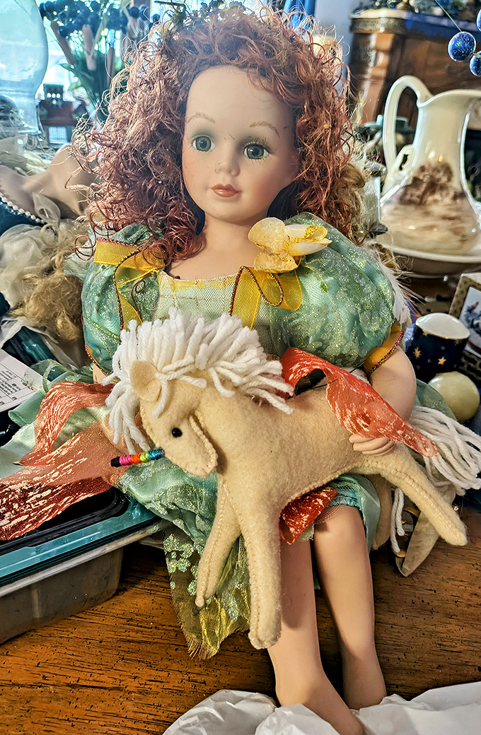 Porcelain perfection meets childhood nostalgia in this red-haired doll, complete with felt unicorn companion&mdash;someone's cherished memory.