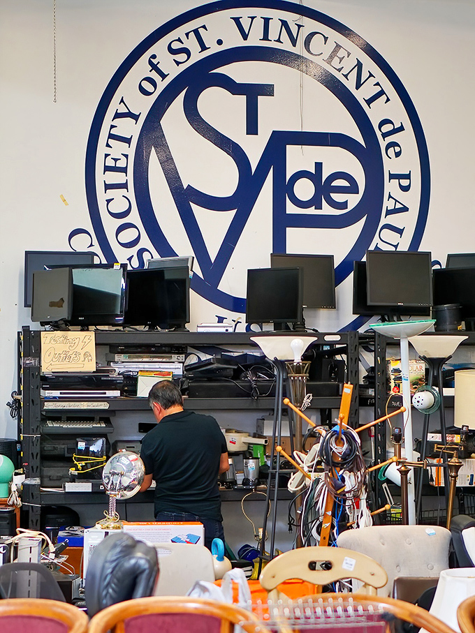 Electronics and lamps beneath the watchful eye of the St. Vincent de Paul logo&mdash;tested, approved, and ready for new homes.