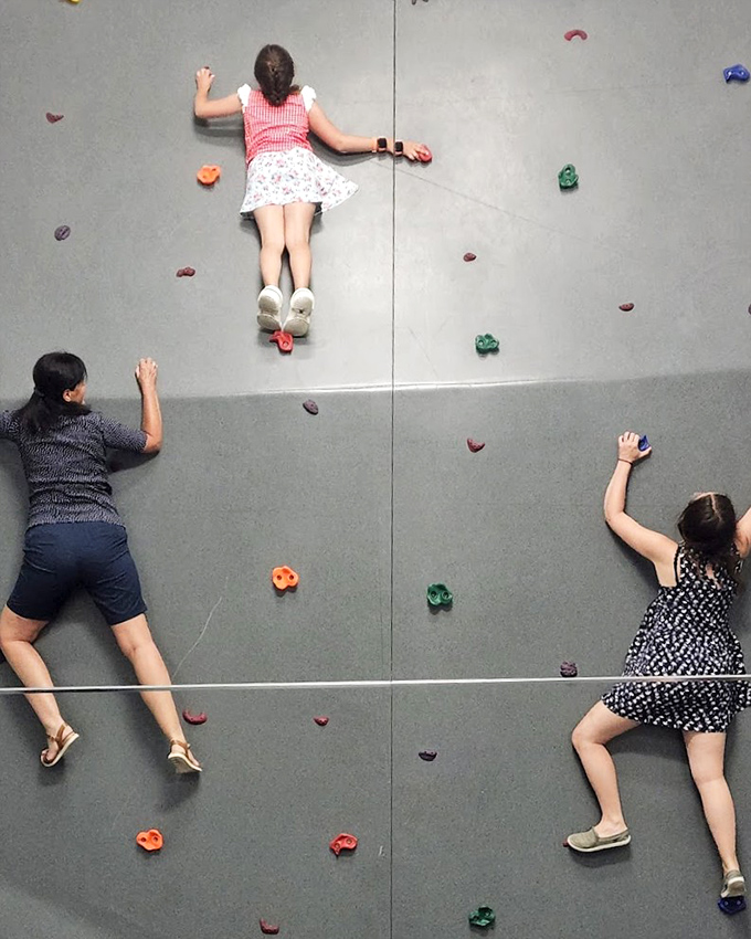 This climbing wall illusion transforms a flat floor into a vertical challenge. Gravity seems optional in this mind-bending photo opportunity.
