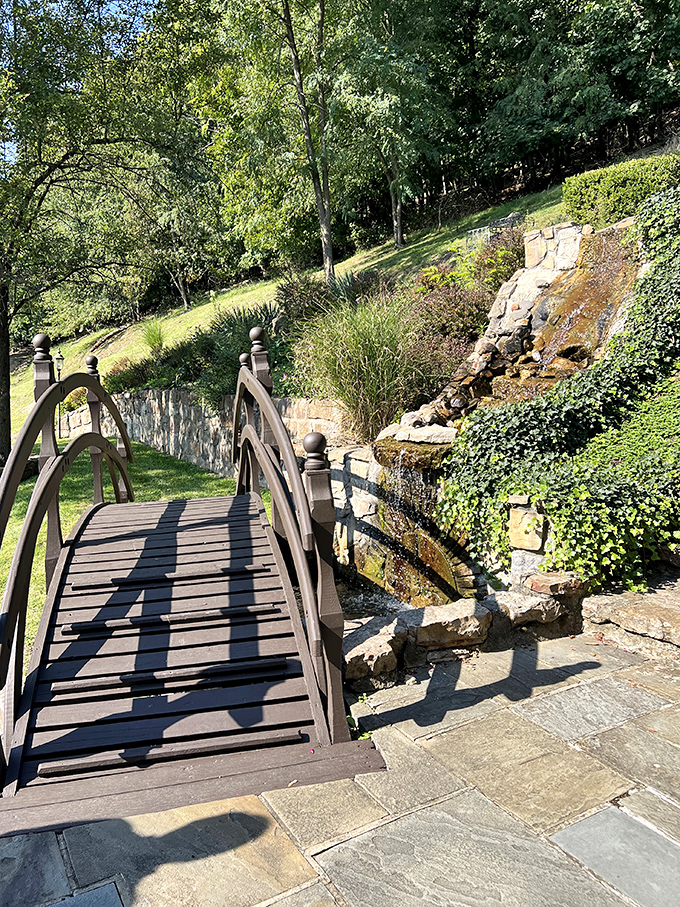 A footbridge worthy of poetry leads visitors across a gentle stream&mdash;no moat monsters included, though I'm sure they were considered.