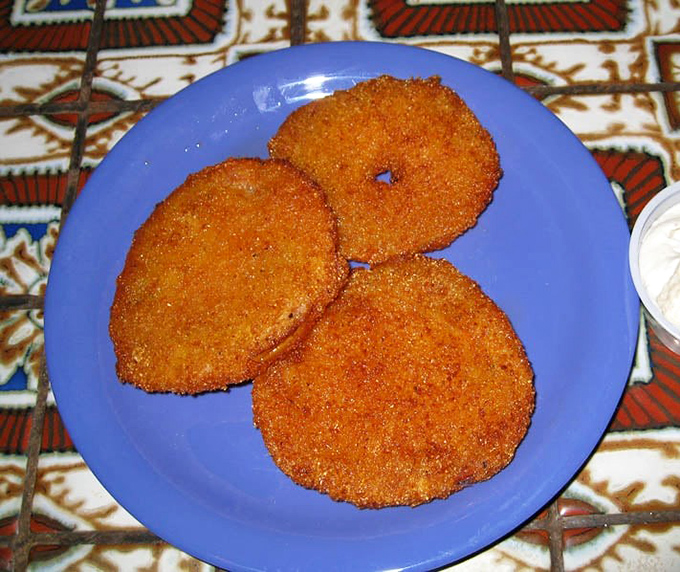 Crispy cornmeal coating reveals tangy perfection in these fried green tomatoes that define Southern tradition.