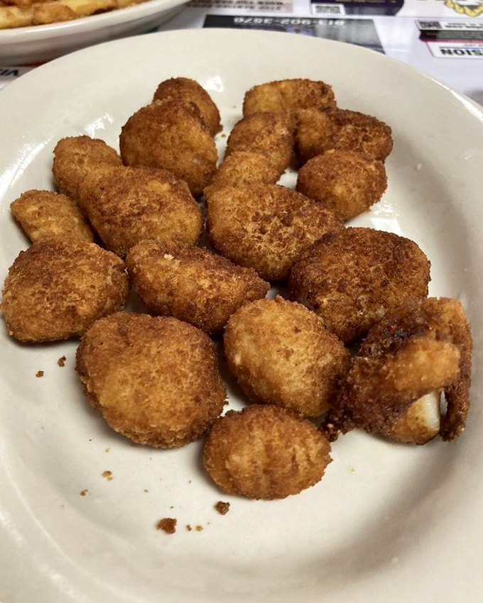 Golden-fried scallops that crunch then melt, proving that sometimes the simplest preparations yield the most profound satisfaction.