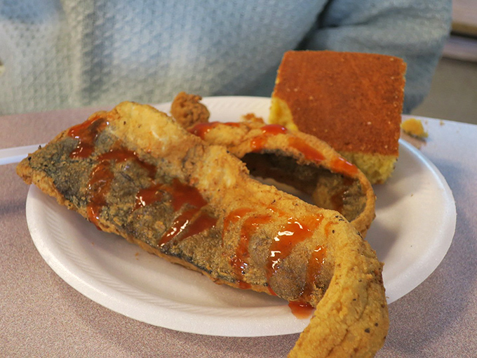 Crispy fried fish with a side of cornbread&mdash;proof that simple pleasures, when done right, can be the most profound.