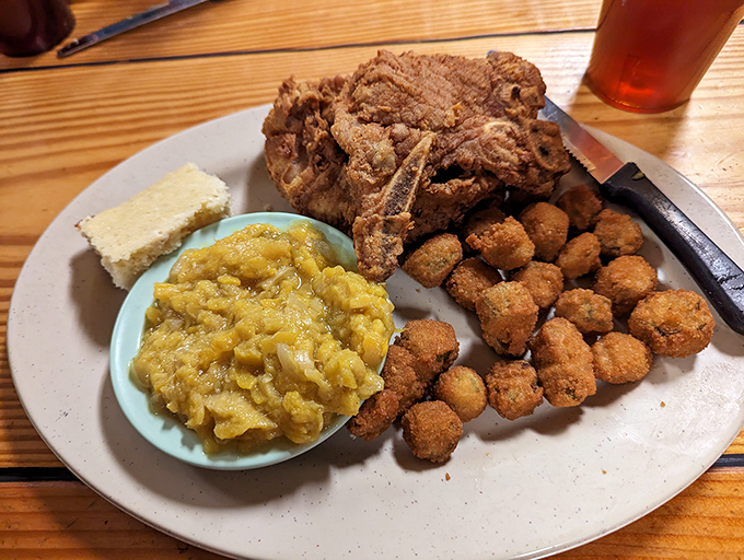 Southern comfort on a plate. That pork chop has been fried with such reverence it practically deserves its own hymn.