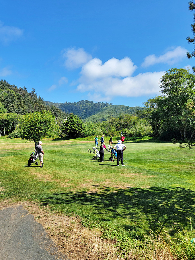 Golfers pause mid-round to soak in mountain views that make even a triple-bogey feel like a win in this coastal paradise.