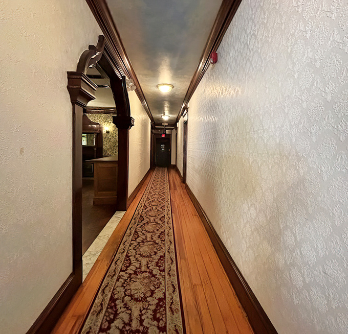 The hallway's vintage charm hints at the building's history&mdash;wooden floors and ornate runner creating a pathway to dining satisfaction.