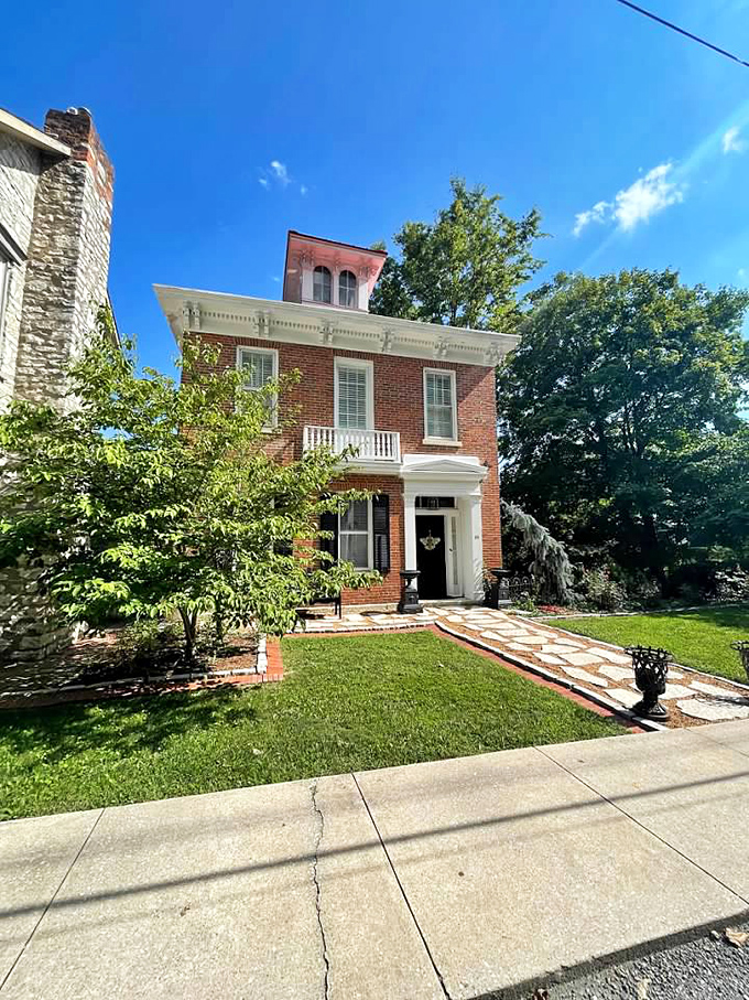 This Italianate brick beauty stands proud against a perfect blue Illinois sky, its ornate cornice and balanced proportions a masterclass in 19th-century architecture.