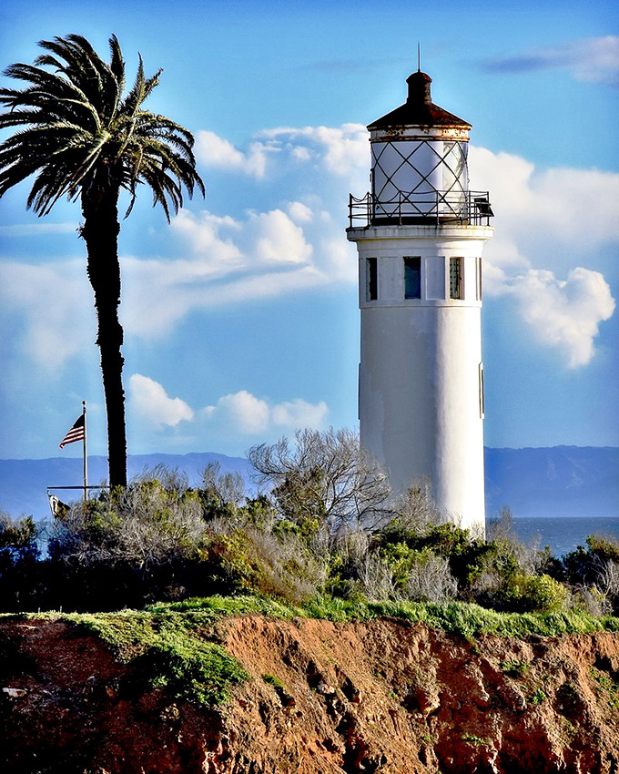 The lighthouse stands proudly against clouds that look like they were ordered specially from Central Casting for a perfect backdrop.