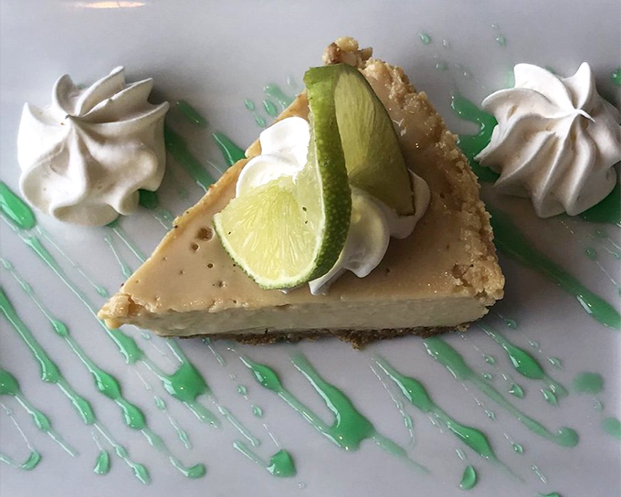 Key lime pie with that perfect sweet-tart balance and decorative green swirls&mdash;the kind of dessert that makes you consider ordering a second slice "for the road."