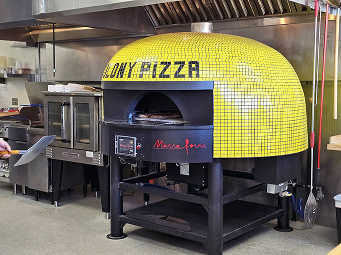 The yellow-tiled pizza oven stands like a beacon of hope in the kitchen, promising perfectly blistered crusts and melty cheese with every creation.