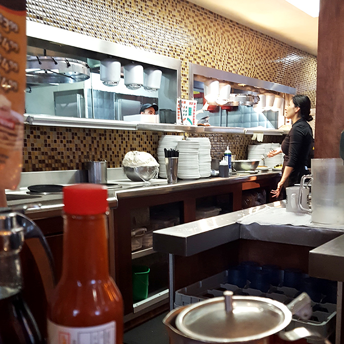 Where breakfast magic happens. The open kitchen design lets you witness the choreography of short-order cooking&mdash;a delicious dance that ends on your plate.