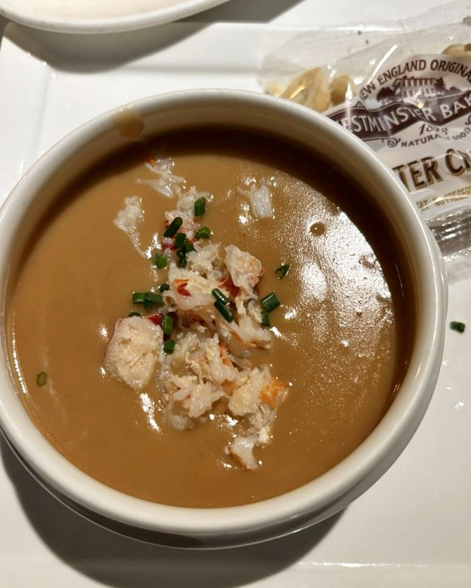 Lobster bisque so rich it probably has its own offshore account. That little island of crab meat in the center? Pure treasure.