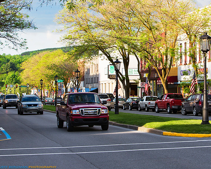 The Roost and neighboring establishments create a vibrant streetscape where outdoor seating turns sidewalks into community gathering spaces.