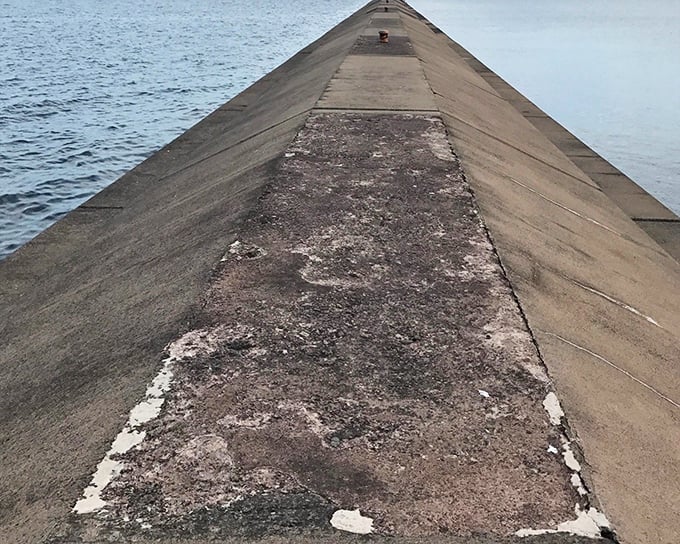 The breakwater stretches toward Lake Superior's horizon like a concrete runway, inviting brave souls to venture into the heart of the great lake.
