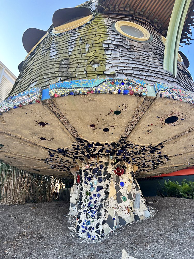 The base of the mushroom tower incorporates colorful mosaic work, like a bejeweled stem supporting this architectural fungi.