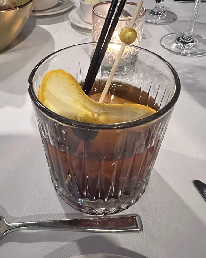 This isn't just an Old Fashioned – it's liquid history with a modern twist, garnished with what appears to be a house-made chip that screams "attention to detail."