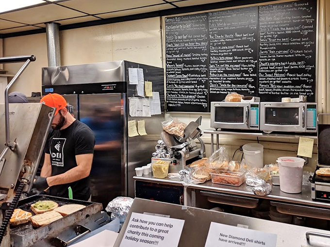 The open kitchen reveals the alchemy of sandwich-making, where ordinary ingredients transform into extraordinary meals under skilled hands.