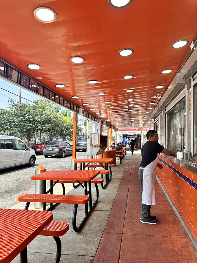 The outdoor seating area, where strangers become friends united by their mutual love of perfectly crafted sandwiches under that signature orange canopy.
