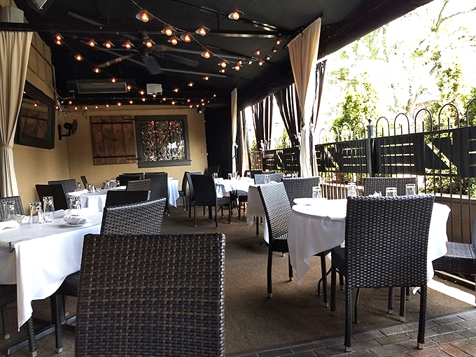 The outdoor patio offers al fresco dining with string lights creating a magical atmosphere. Summer evenings were made for spaces like this.