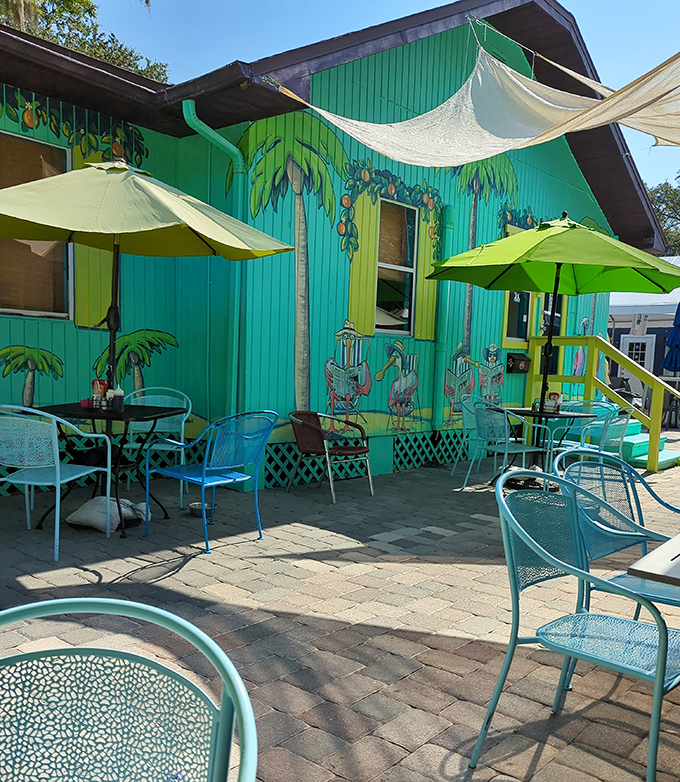 Tropical vibes meet breakfast bliss in this outdoor oasis. Palm tree murals and turquoise chairs create a "vacation morning" even on a Tuesday.