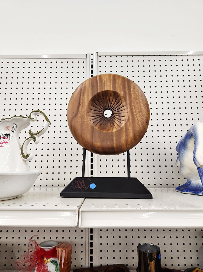 Unique decorative pieces like this wooden sculpture transform the ordinary thrift trip into an unexpected art gallery experience.