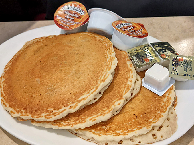 Pancakes stacked higher than your weekend ambitions, golden-brown and ready for their maple syrup waterfall moment.