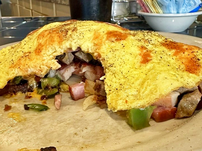 An omelet cut open to reveal its treasure—like a culinary pirate chest spilling with colorful vegetable gems and savory secrets.
