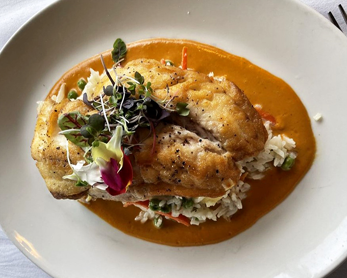 This red snapper dish isn't just food&mdash;it's edible art, with that vibrant sauce creating a sunset backdrop for the perfectly seared fish.