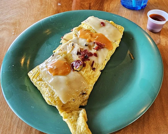An omelet that's been stuffed with so many good things it's practically bursting at the seams, topped with melty cheese and sauce.