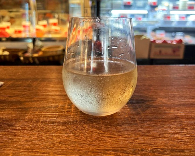 A chilled glass of white wine sitting at the counter &ndash; the perfect companion while waiting for seafood treasures to arrive at your table.