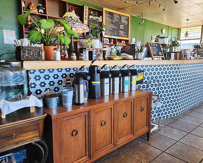 The service counter's blue-and-white tile pattern and thriving plants create the feeling you've wandered into someone's particularly welcoming coastal kitchen.