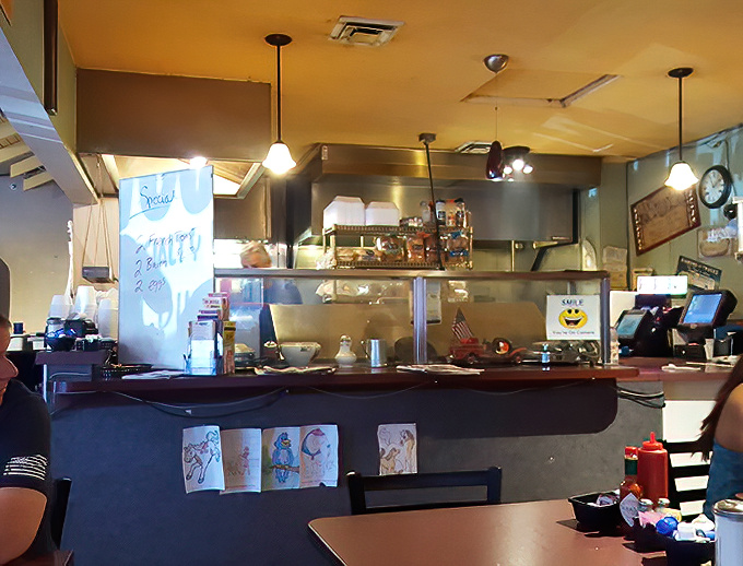 The counter view reveals the organized chaos of a well-run kitchen, where breakfast dreams materialize before your eyes.