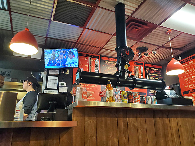 Where the magic happens—industrial efficiency meets Southern hospitality as orders fly and chicken fries beneath those signature red lights.