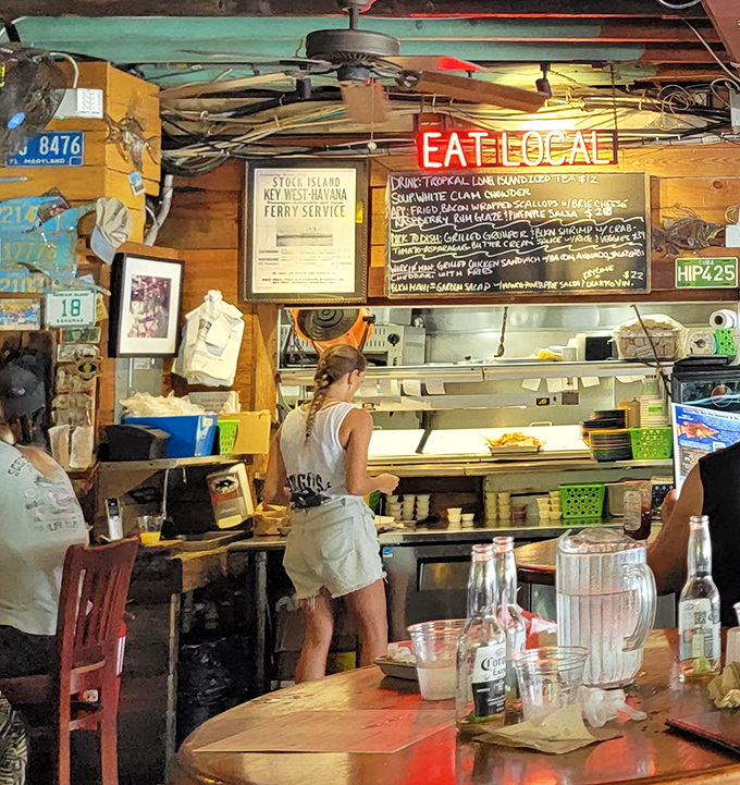 The "EAT LOCAL" sign isn't just decoration&mdash;it's the Hogfish philosophy illuminated in neon, with a chalkboard menu showcasing the day's freshest catches.