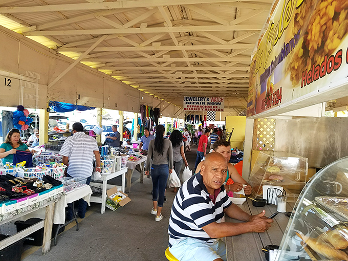 The indoor section offers shade and discoveries in equal measure, with vendors and shoppers engaged in the timeless dance of commerce.
