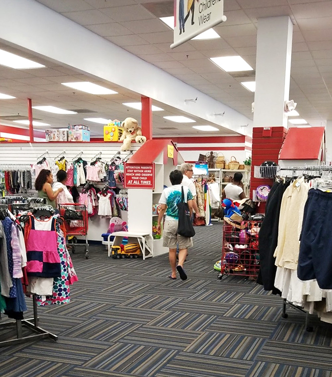 Shoppers navigate the well-organized children's section. That stuffed bear on the top shelf is silently hoping to be someone's new best friend.