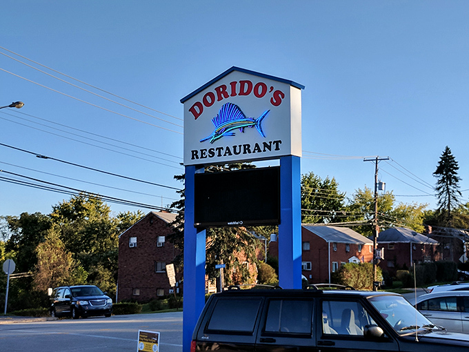The roadside sign stands tall and proud, featuring Dorido's signature sailfish&mdash;a blue-and-white promise of the ocean's bounty waiting inside.