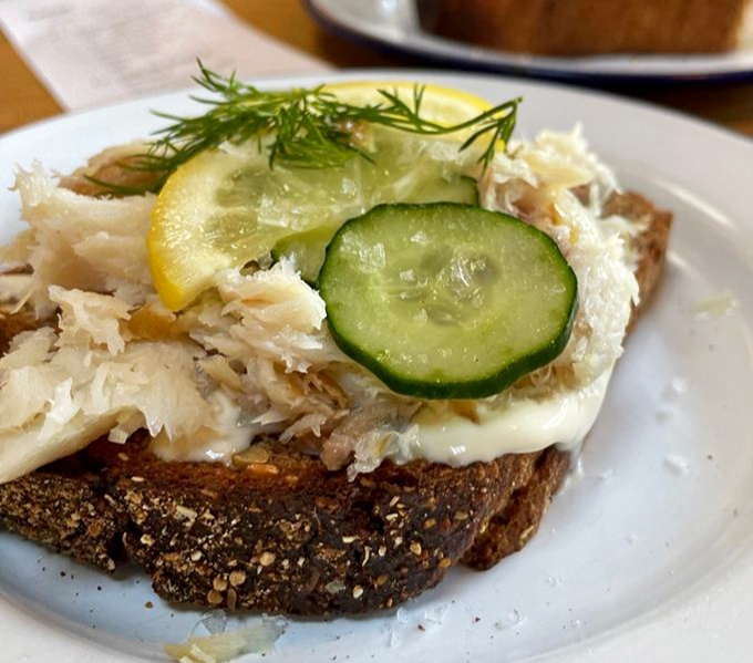 Not your college dorm's fish sandwich. Delicate smoked cod elevated with fresh cucumber and lemon—proof that seafood and bread are soulmates.