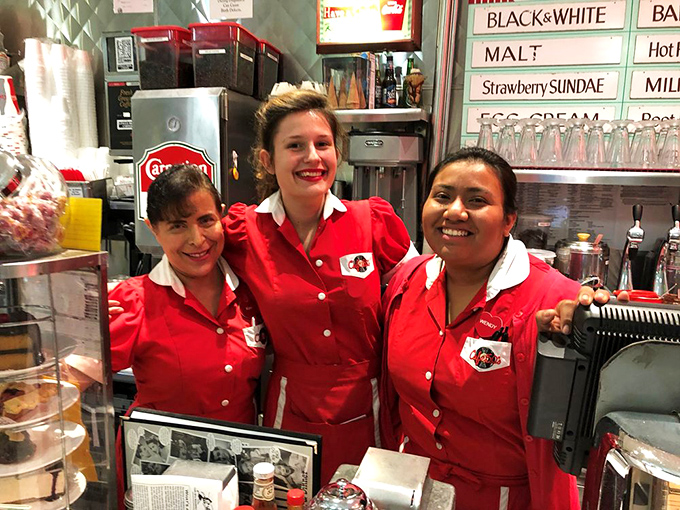 Servers in classic red uniforms with white collars embody the spirit of the era, delivering smiles alongside stacks of pancakes.