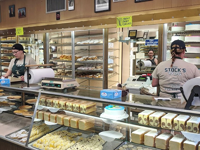 The bakery counter buzzes with activity as staff package up happiness in white boxes tied with string.