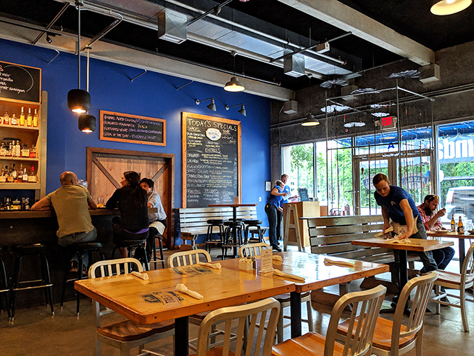 The vibrant blue wall and chalkboard menu create the perfect backdrop for a dining experience that's both casual and memorable.