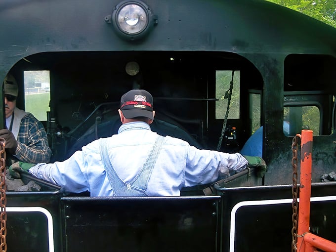 A dedicated crew member tends to the locomotive controls &ndash; part of the passionate team keeping railroad heritage alive for new generations to experience.
